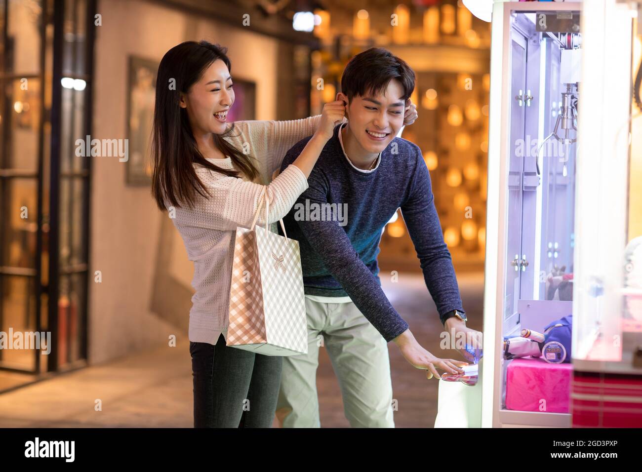 Happy young couple playing toy grabbing game Stock Photo - Alamy