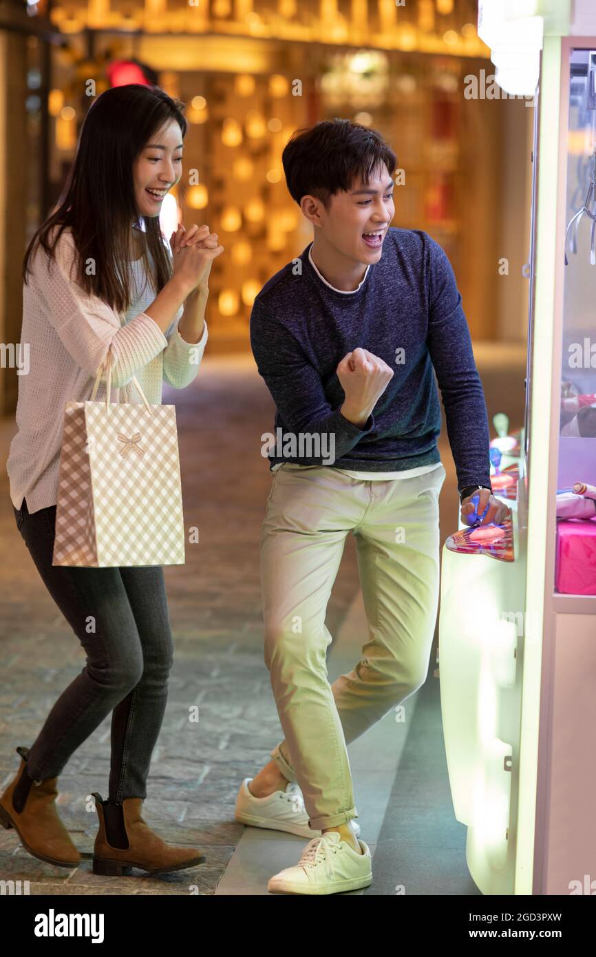 Happy young couple playing toy grabbing game Stock Photo - Alamy