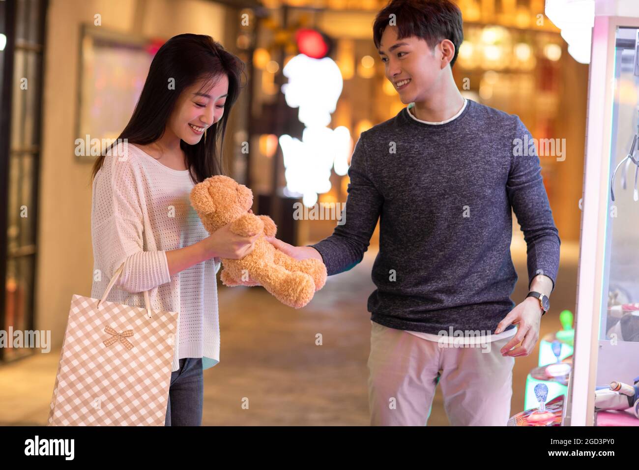 Happy young couple playing toy grabbing game Stock Photo - Alamy