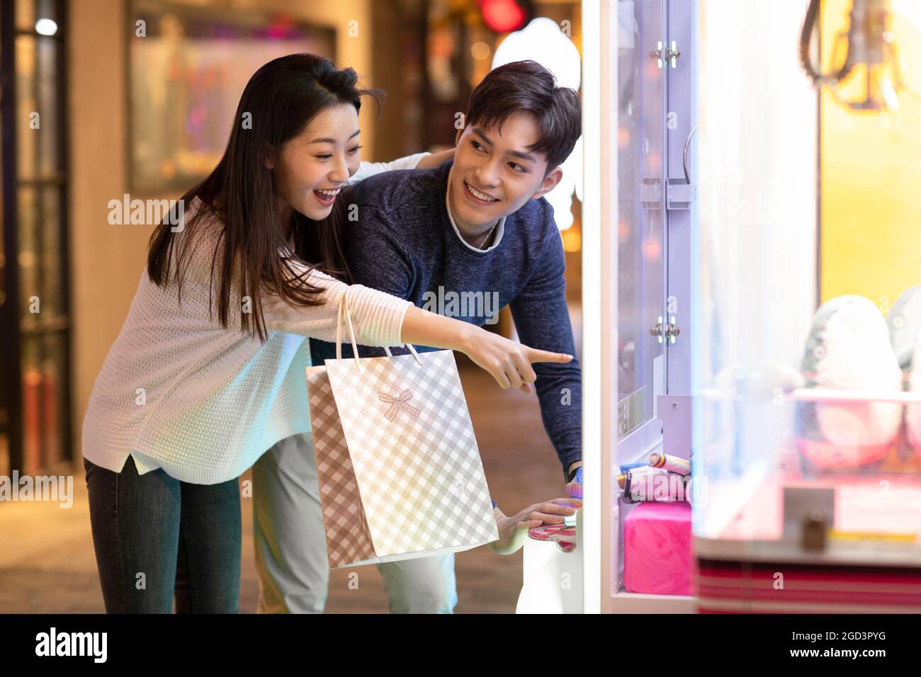 Happy young couple playing toy grabbing game Stock Photo - Alamy
