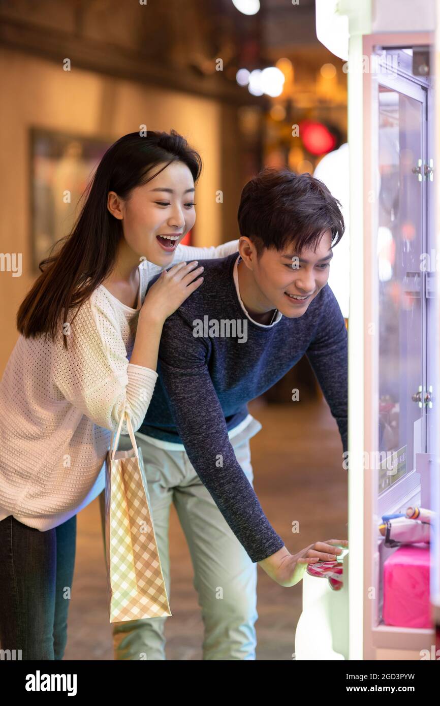 Happy young couple playing toy grabbing game Stock Photo - Alamy