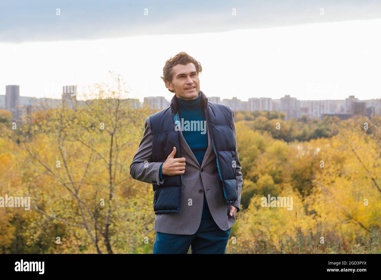 Tall handsome man walking outdoor in yellow autumn forest on the hill ...