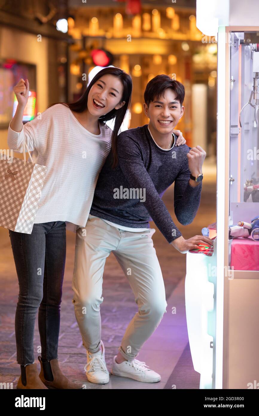 Happy young couple playing toy grabbing game Stock Photo - Alamy