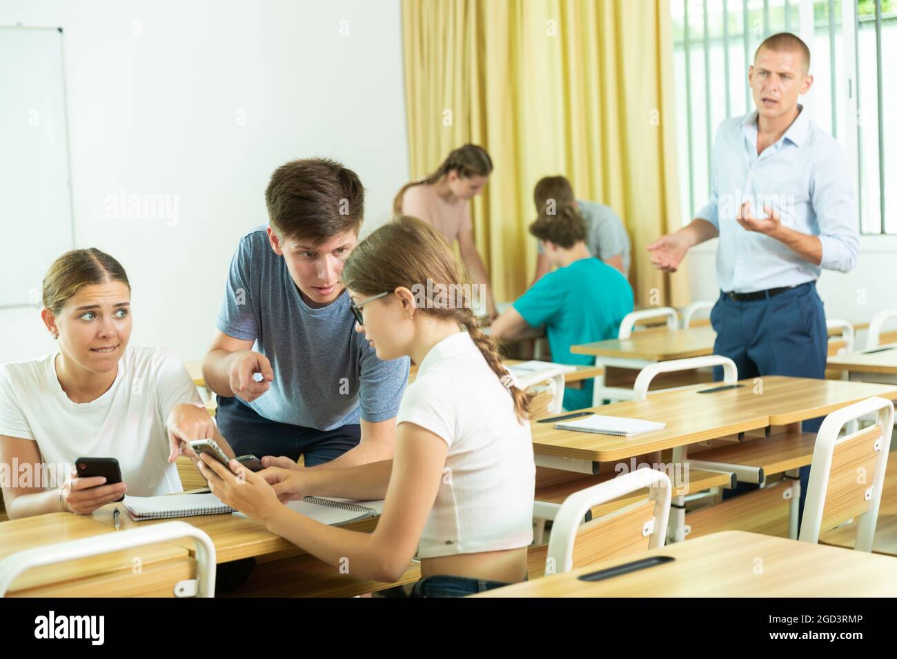 Classmates and teacher working in groups to complete task during class ...