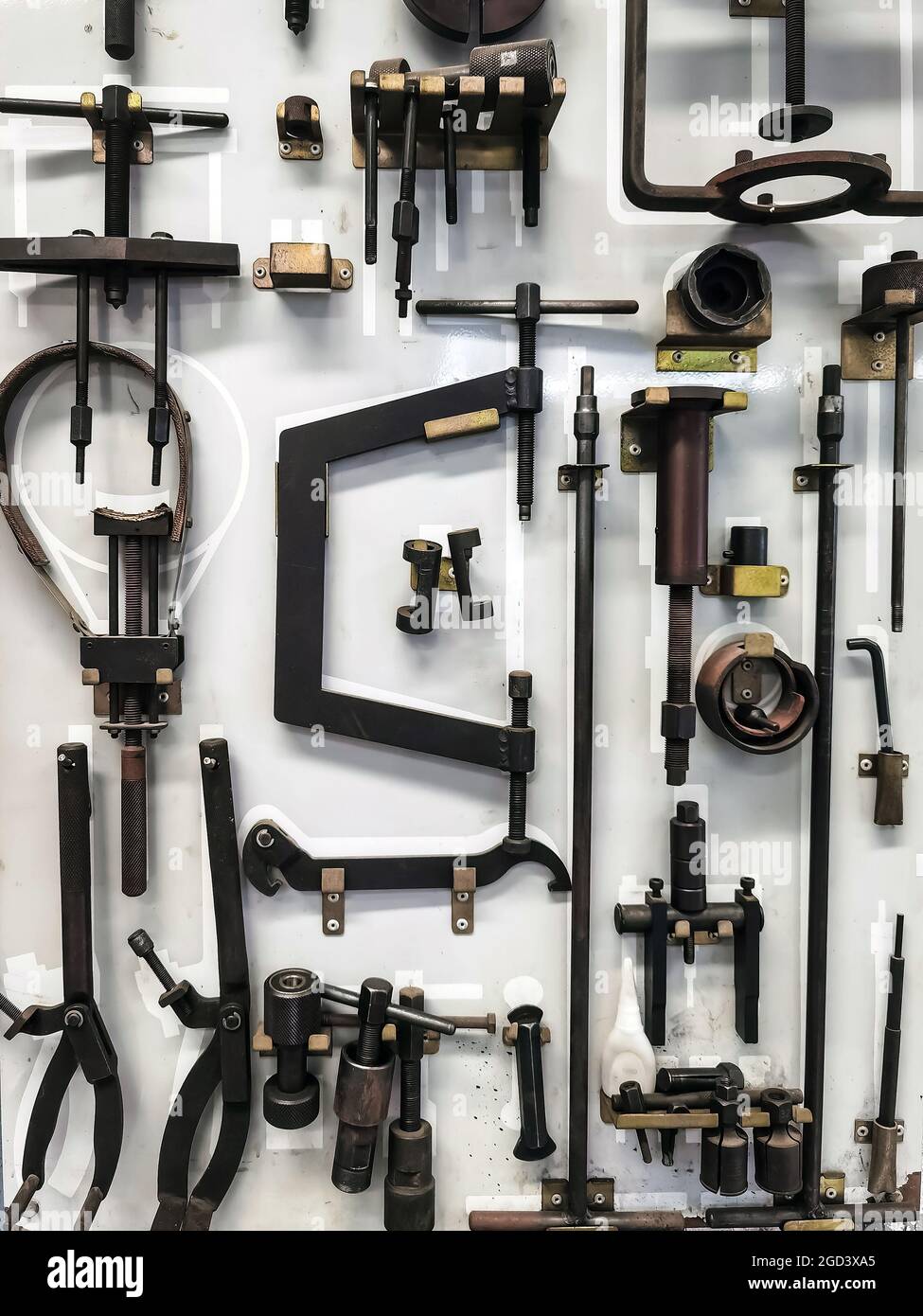 Many tools for repairing motorcycles hanging on wall in workshop. Set ...