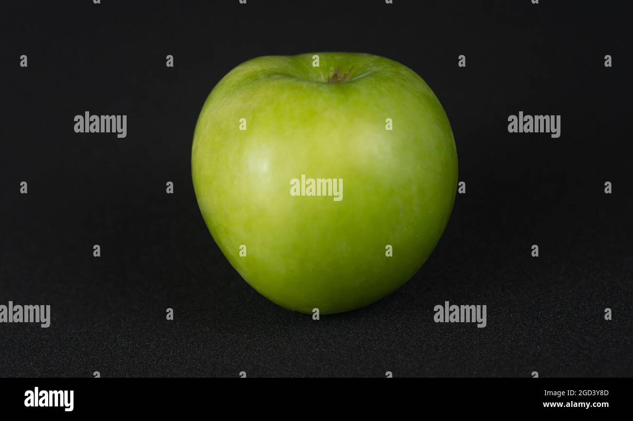 Green apple isolated on a black background with free space for tex ...