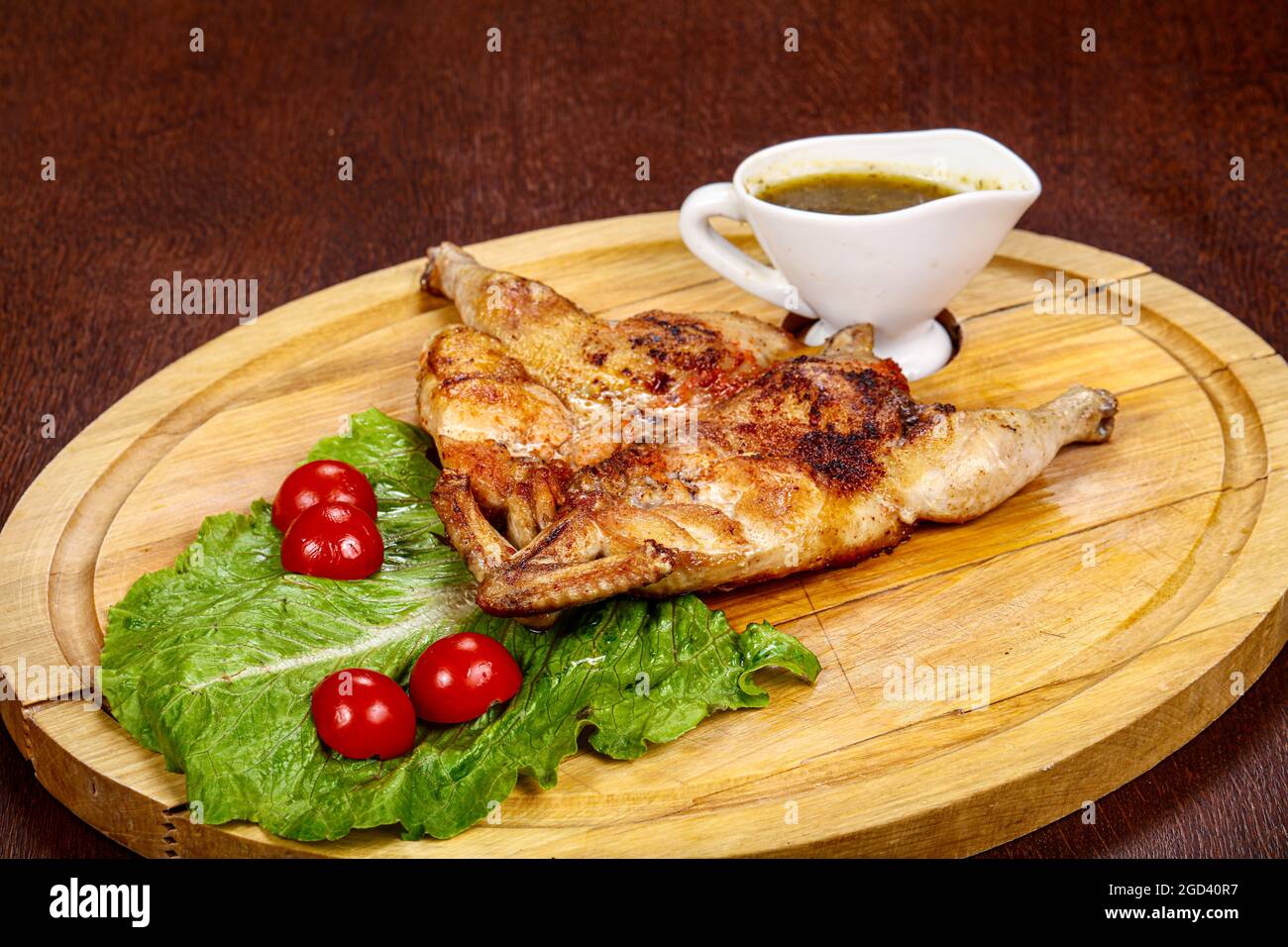 Roasted small chicken with sauce on the plate Stock Photo - Alamy