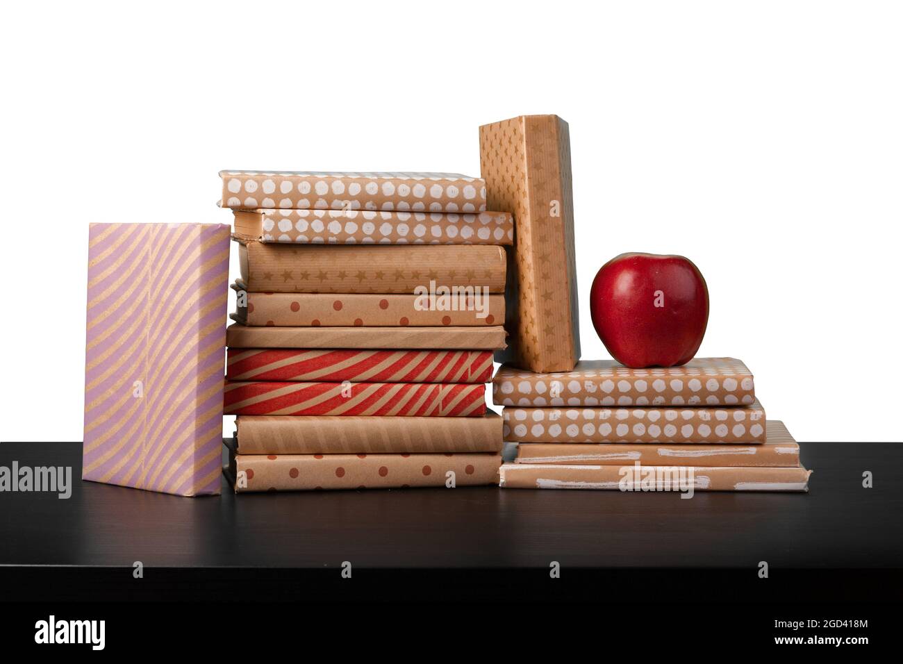 Stack of books and apple on tabletop against white background Stock ...