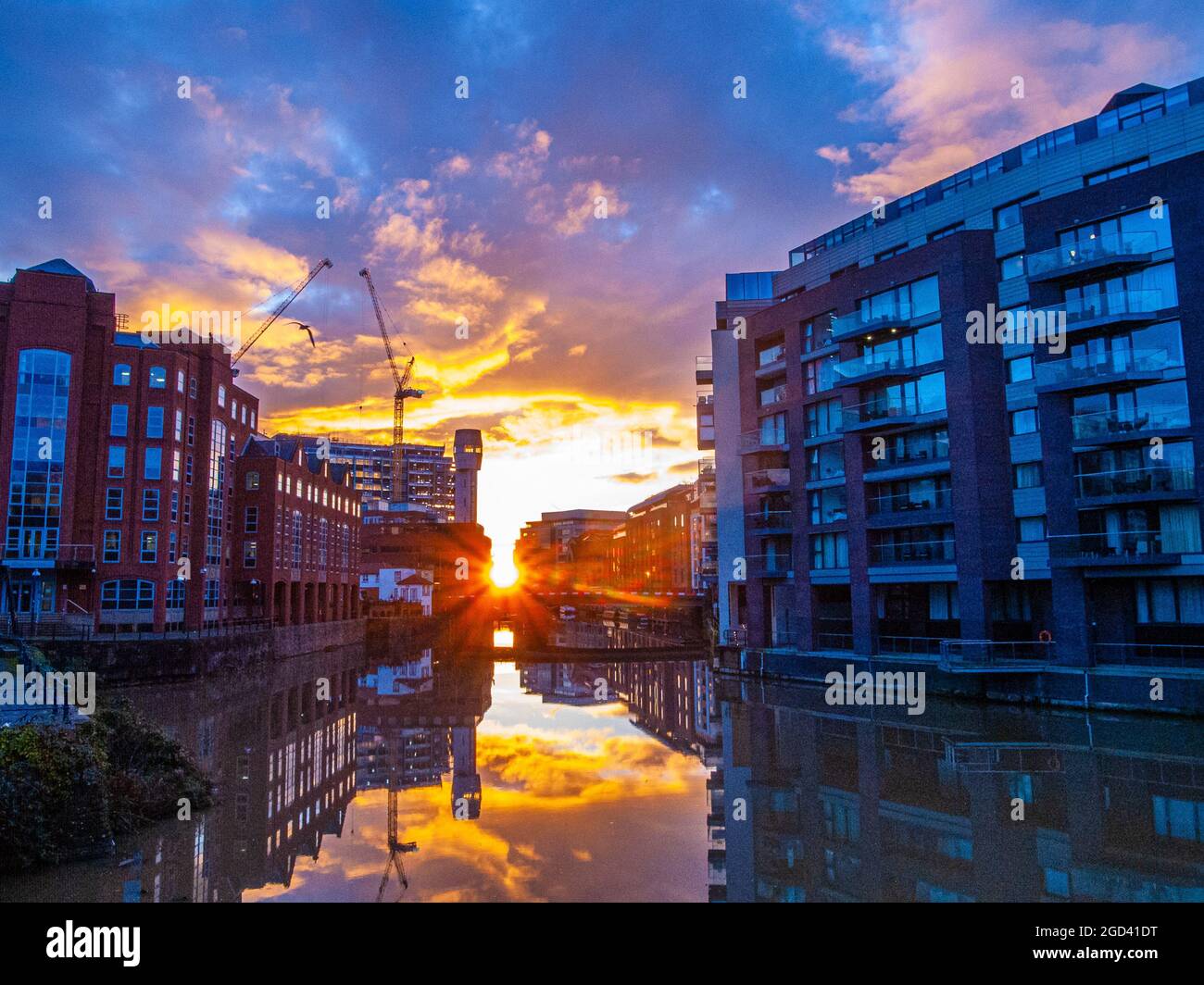 Morning sunlight streaming through a gap in dockside buildings with a ...