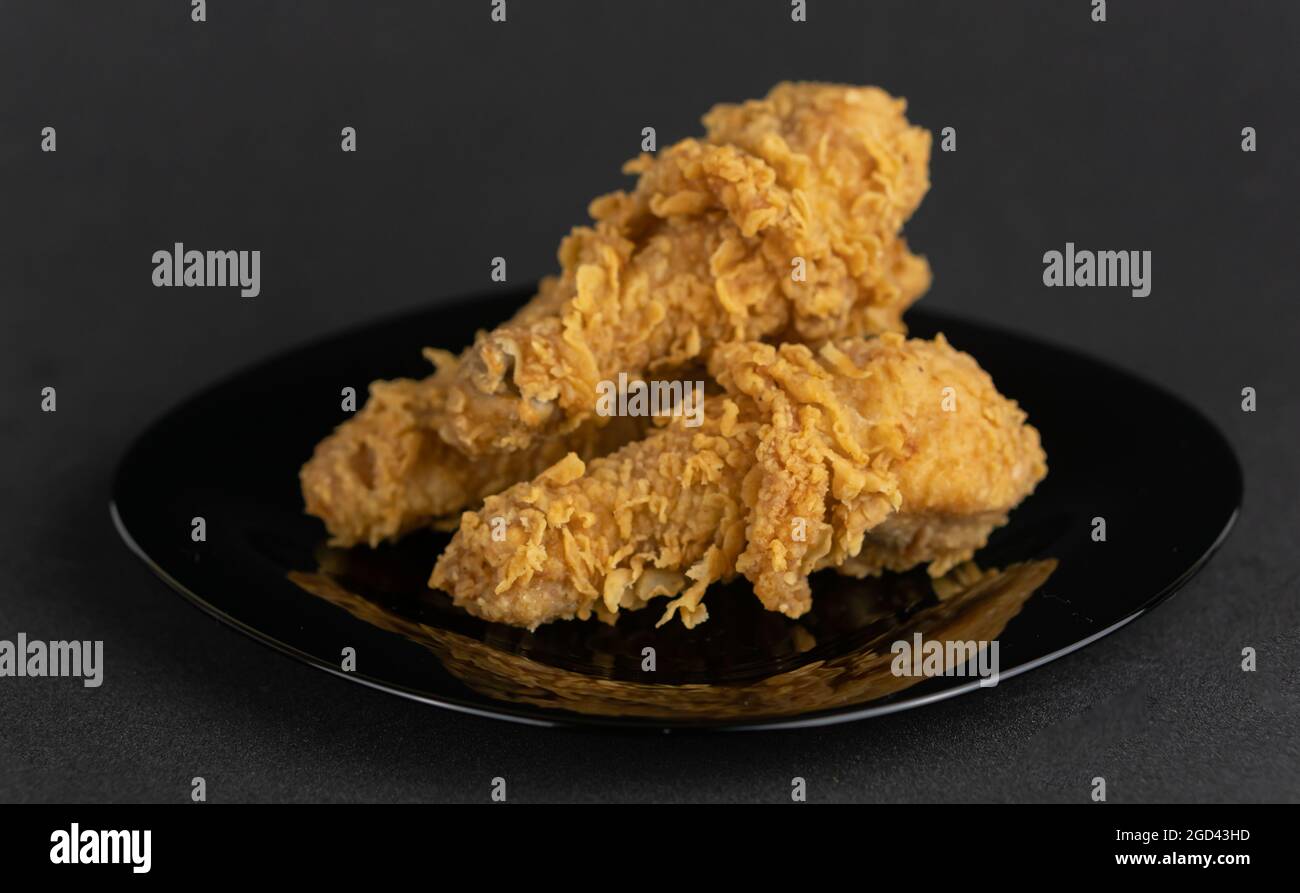 Plate with crispy fried chickens isolated on a black background Stock ...