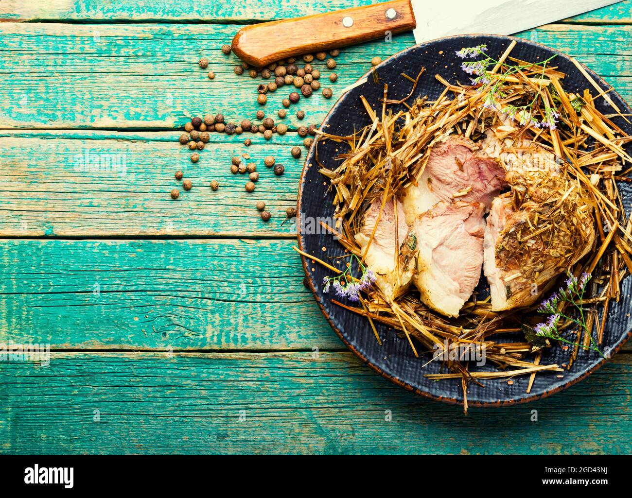 Meat roasted in fresh hay. Baked pork meat in spicy herbs.Autumn food ...
