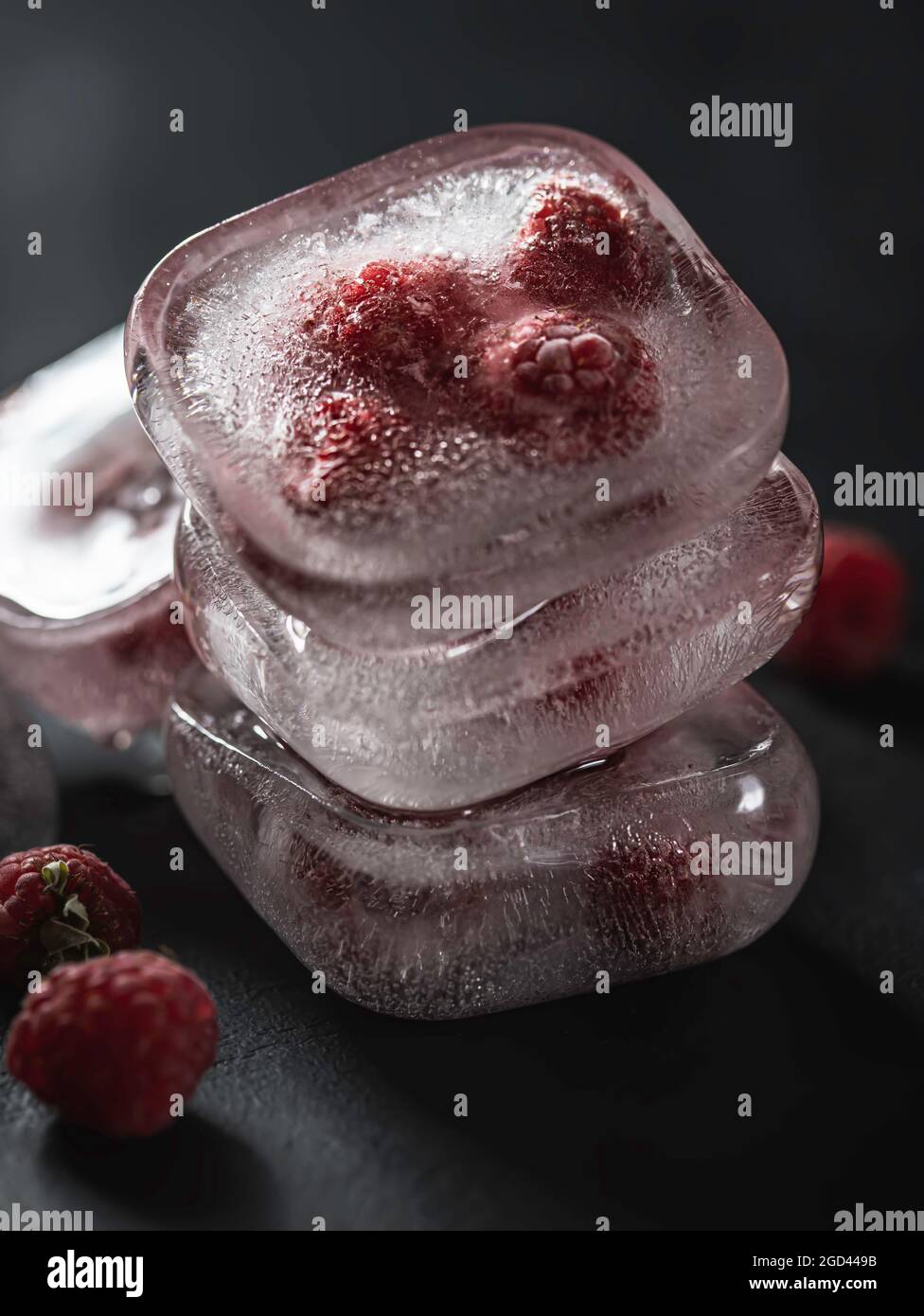 Raspberry frozen in the ice cube on black background. Fresh healthy ...