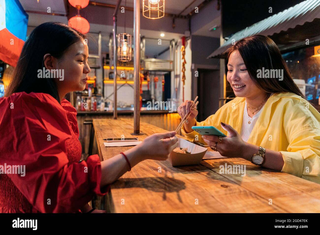 Happy asian female friends sitting in chinese restaurant eating and ...