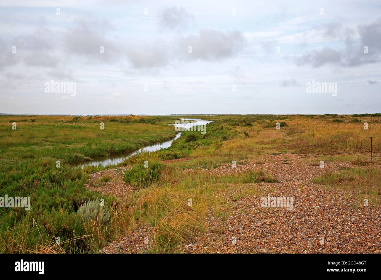 The River Glaven flowing on the landward side of the shingle beach ...