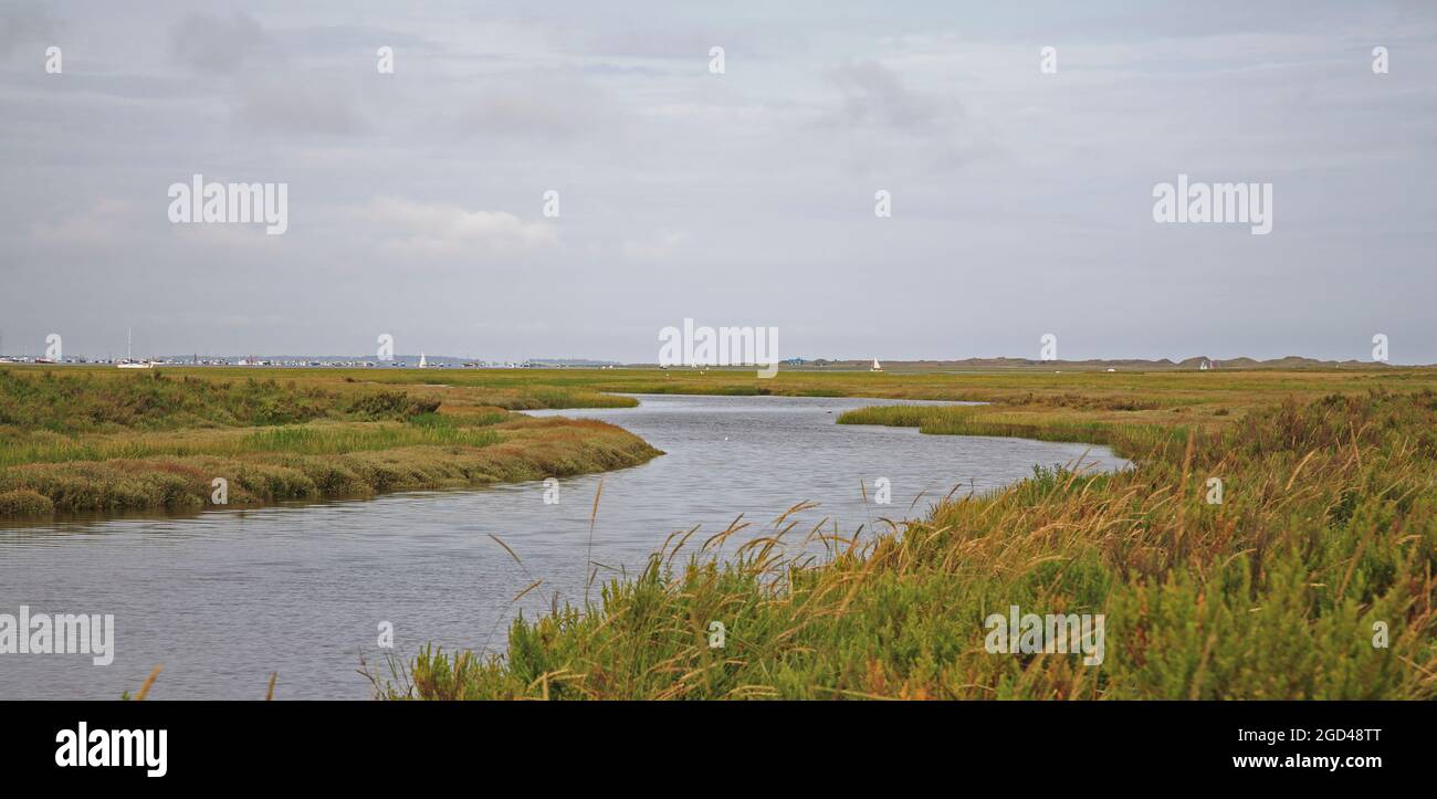 The River Glaven flowing on the landward side of the shingle beach ...