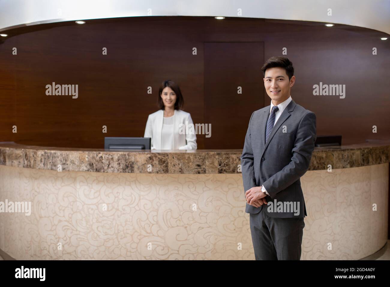 Hotel receptionists at front desk Stock Photo - Alamy