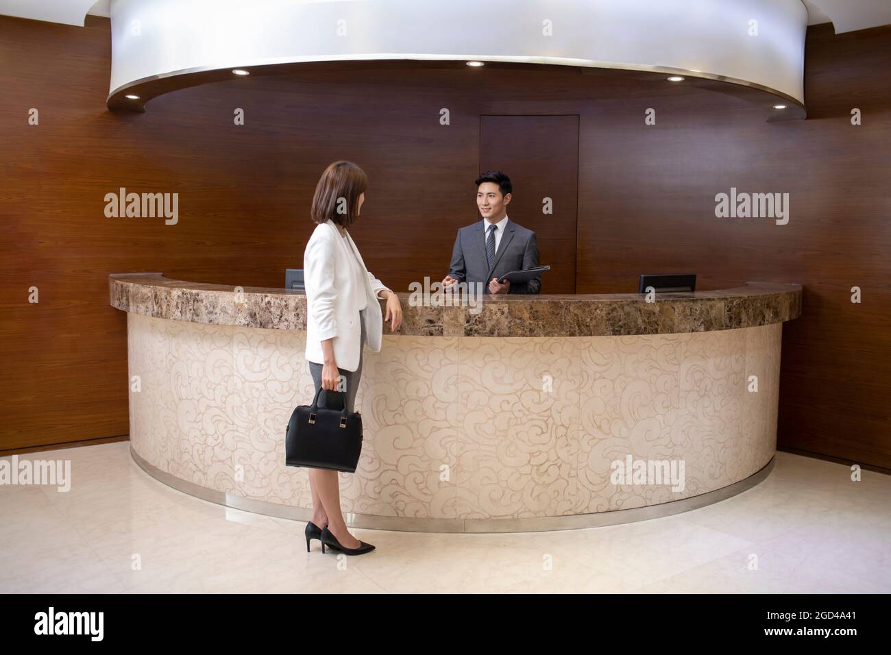 Hotel receptionist talking with customer Stock Photo - Alamy
