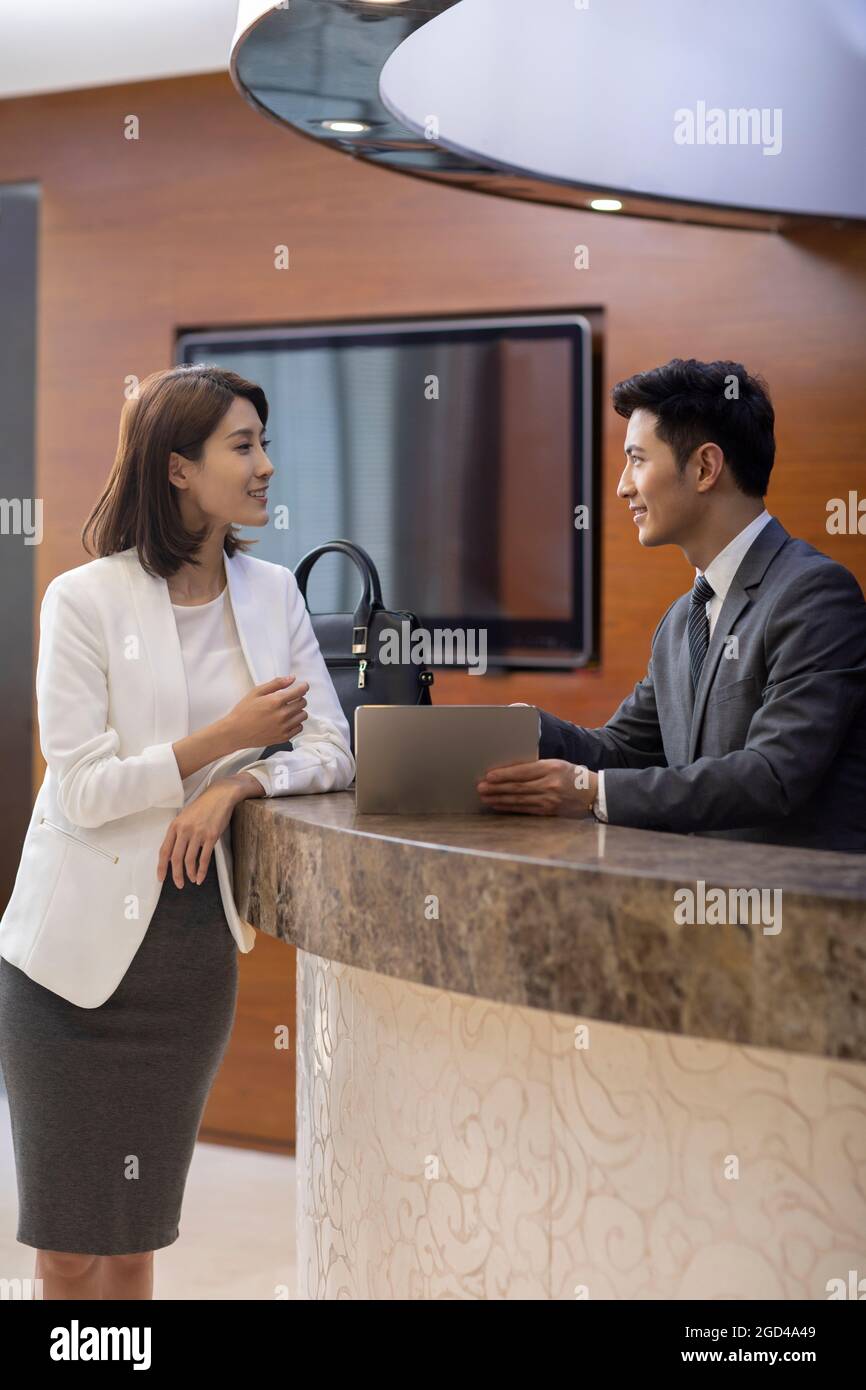 Hotel receptionist talking with customer Stock Photo - Alamy