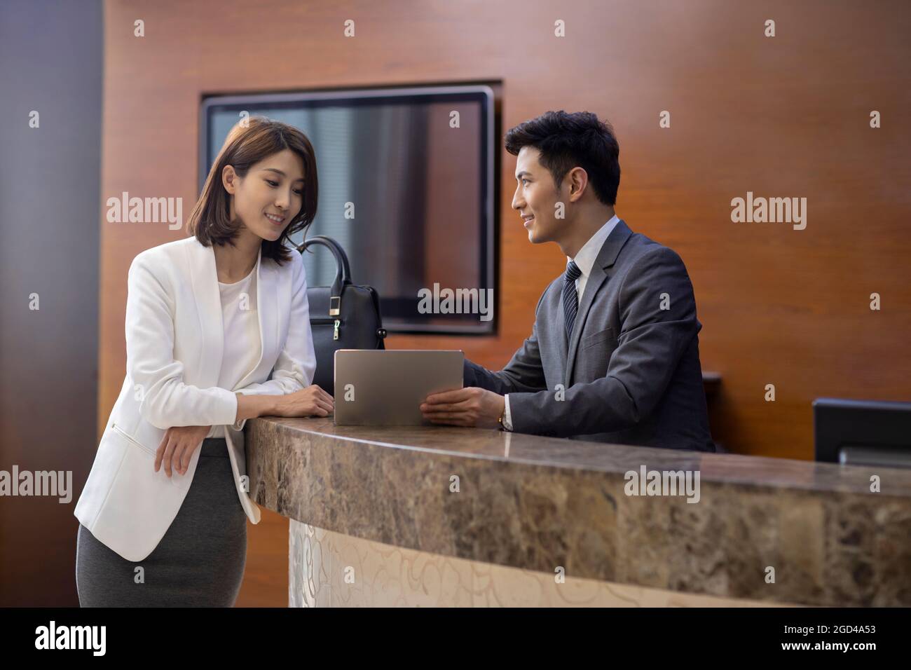 Hotel receptionist talking with customer Stock Photo - Alamy