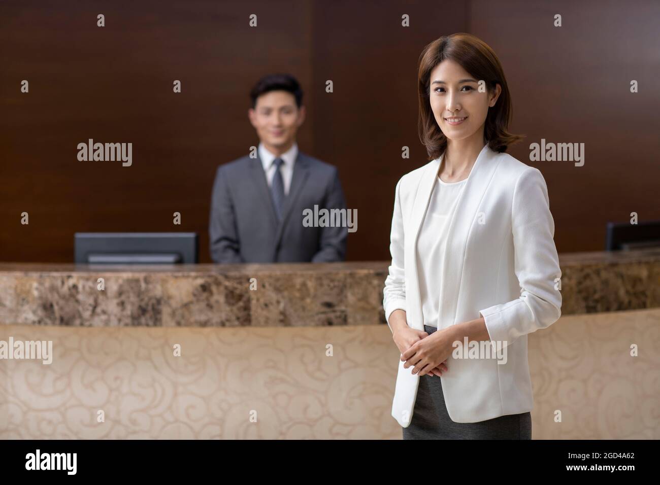 Hotel receptionists at front desk Stock Photo - Alamy
