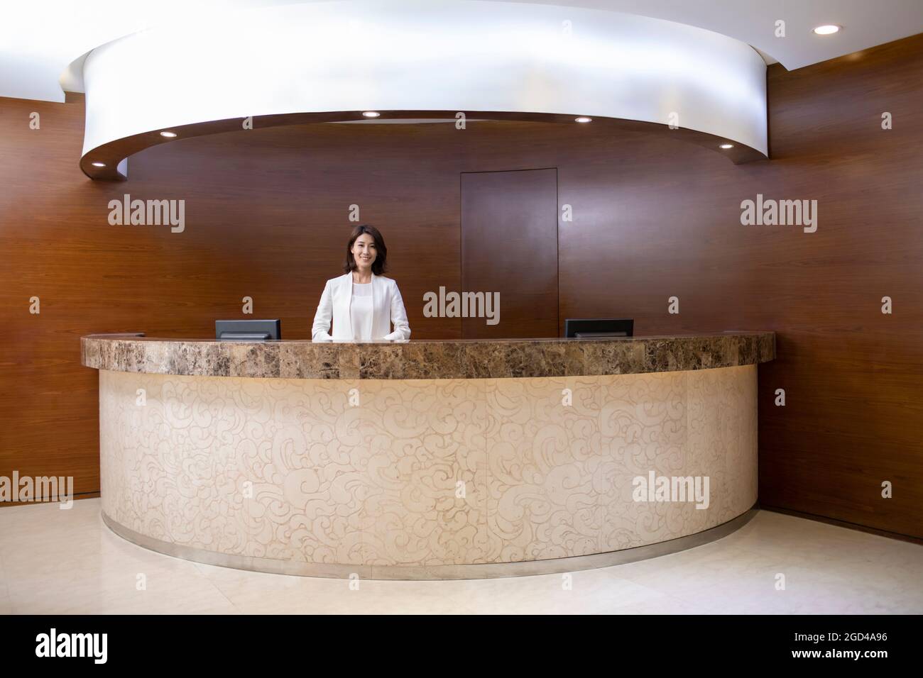 Hotel receptionist at front desk Stock Photo - Alamy