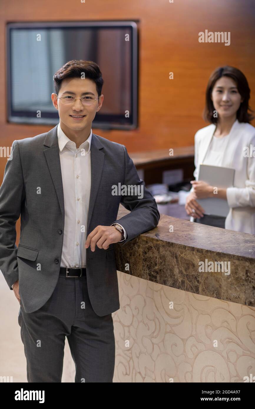 Businessman checking in at front desk Stock Photo - Alamy