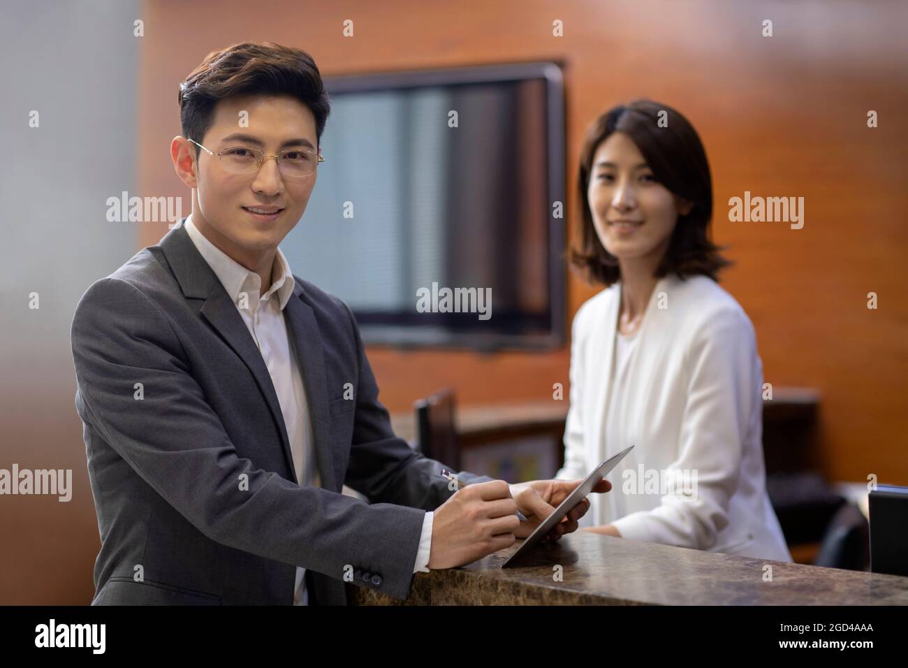 Businessman checking in at front desk Stock Photo - Alamy