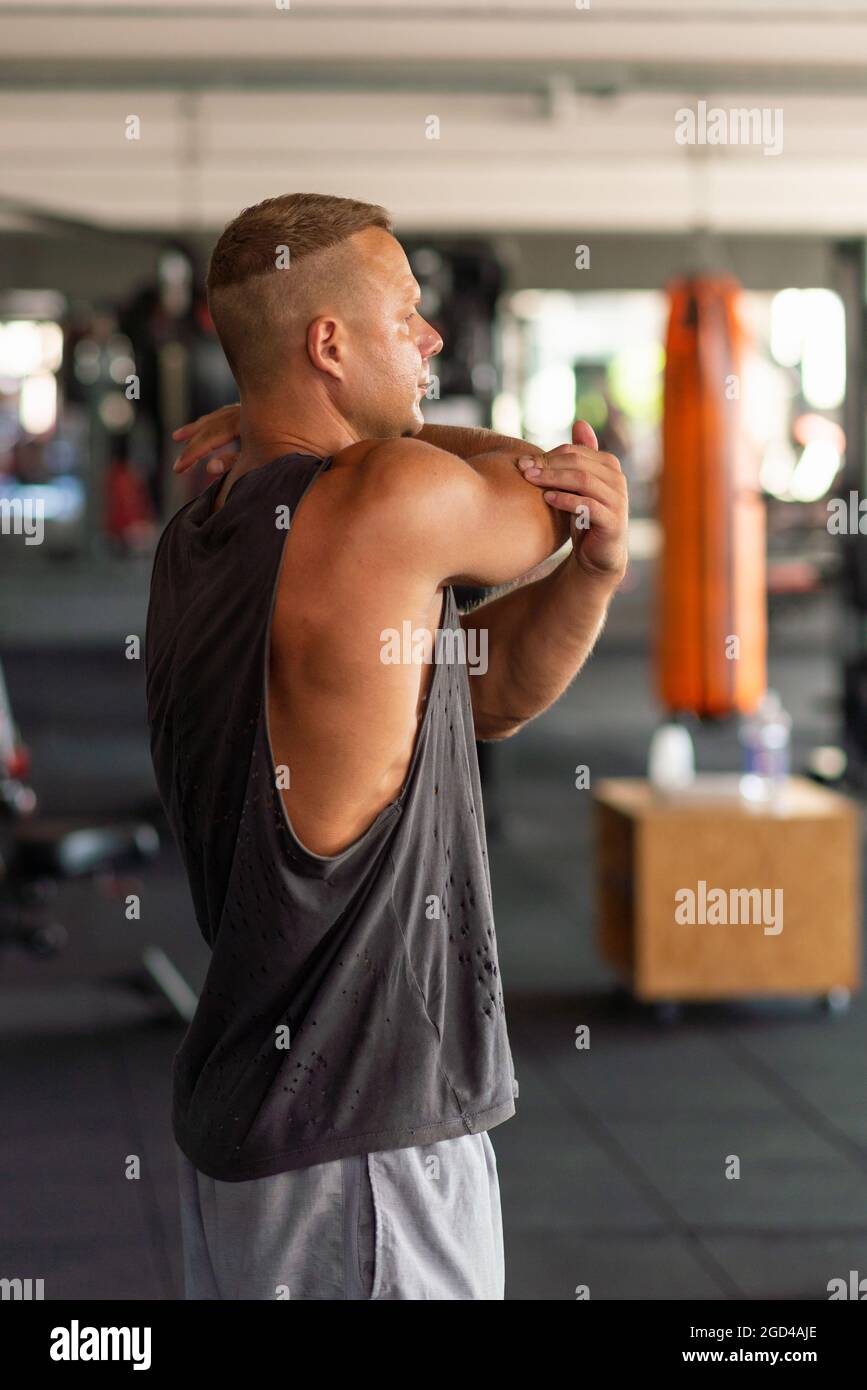 Fitness man warming up in gym. Male doing warm up stretching workout on ...