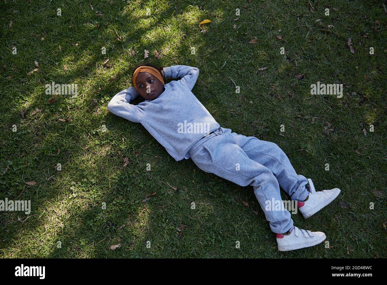 Top down portrait of young black girl lying on grass Stock Photo - Alamy