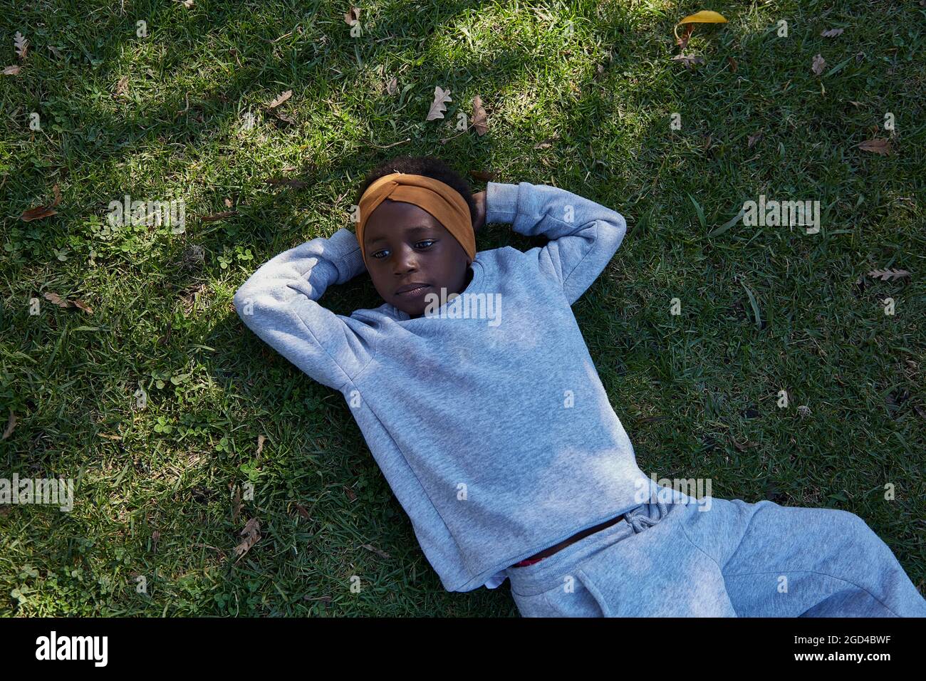 Top down portrait of young black girl lying on grass Stock Photo - Alamy