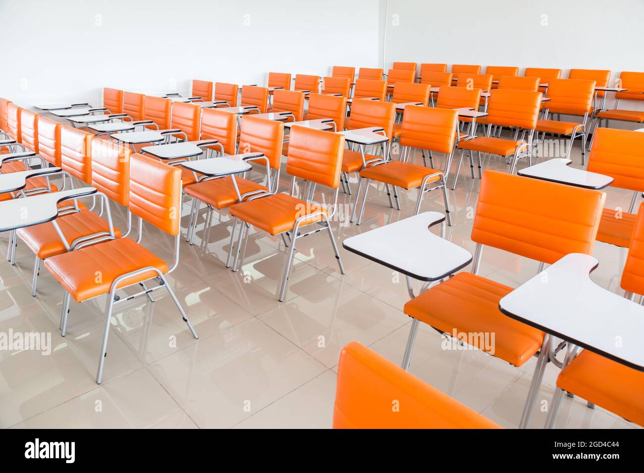 classroom with many orange armchairs background Stock Photo - Alamy