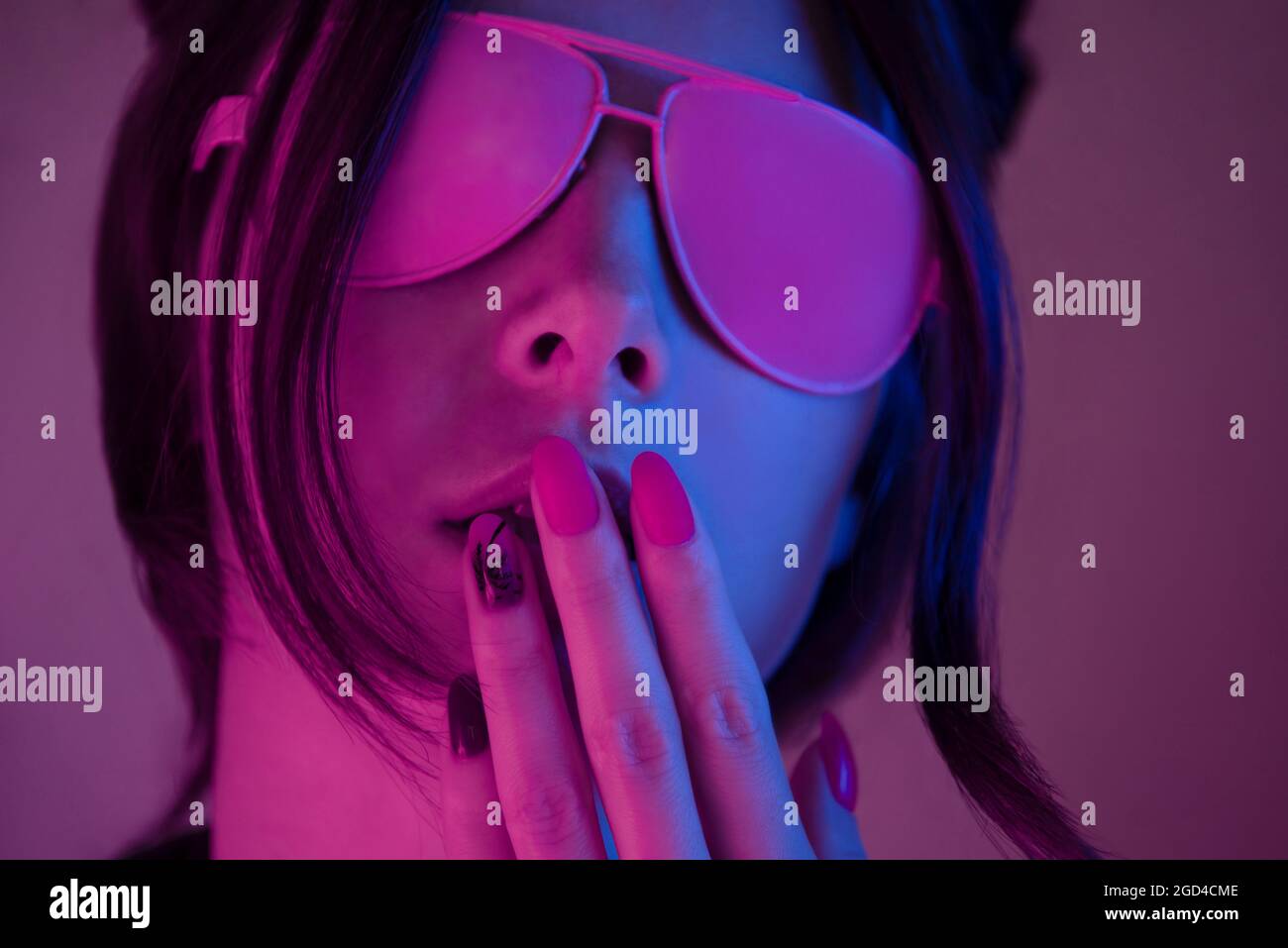 Sensual young woman portrait in pink neon light Stock Photo - Alamy