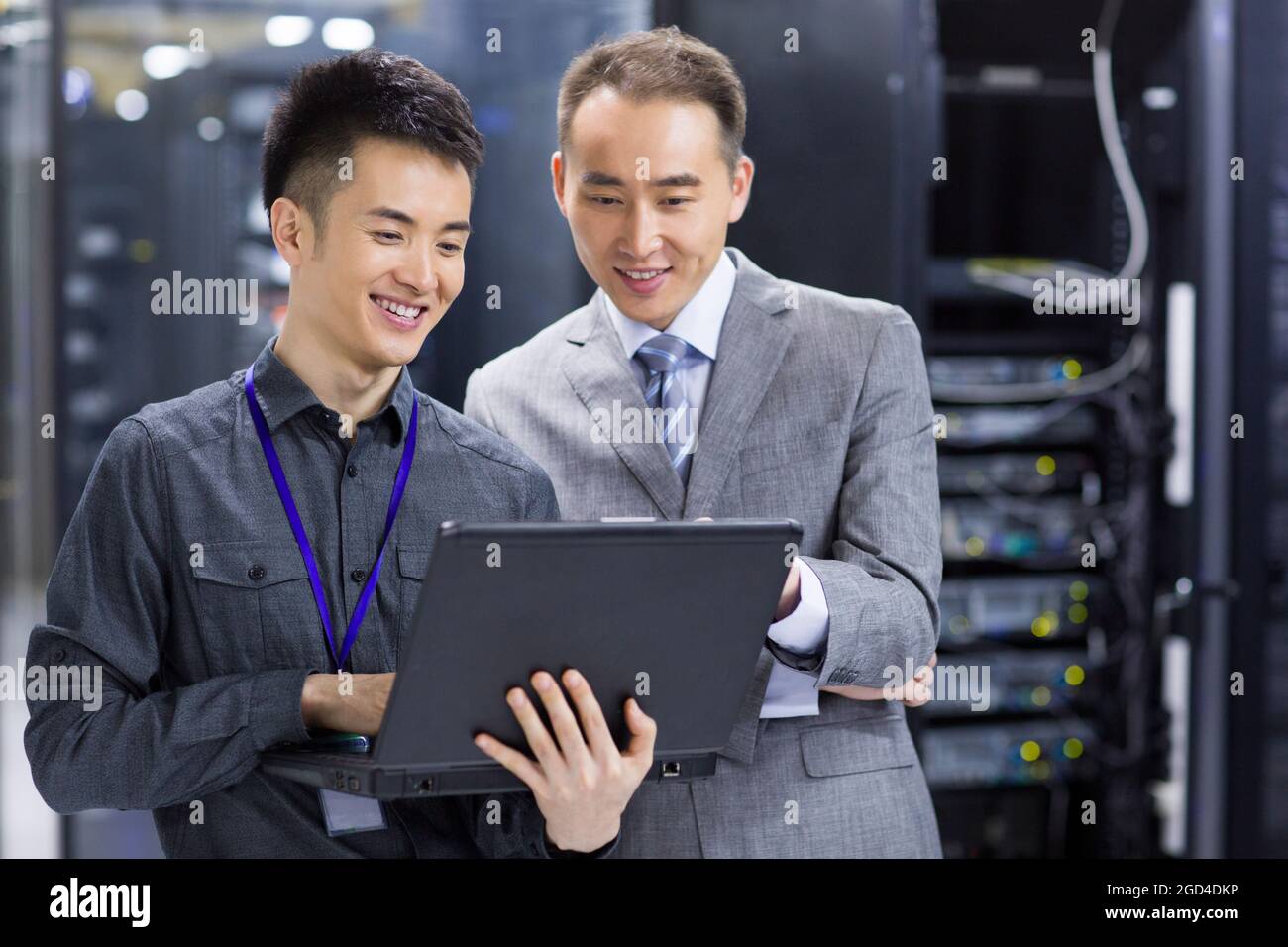 Technician using laptop in computer room Stock Photo - Alamy