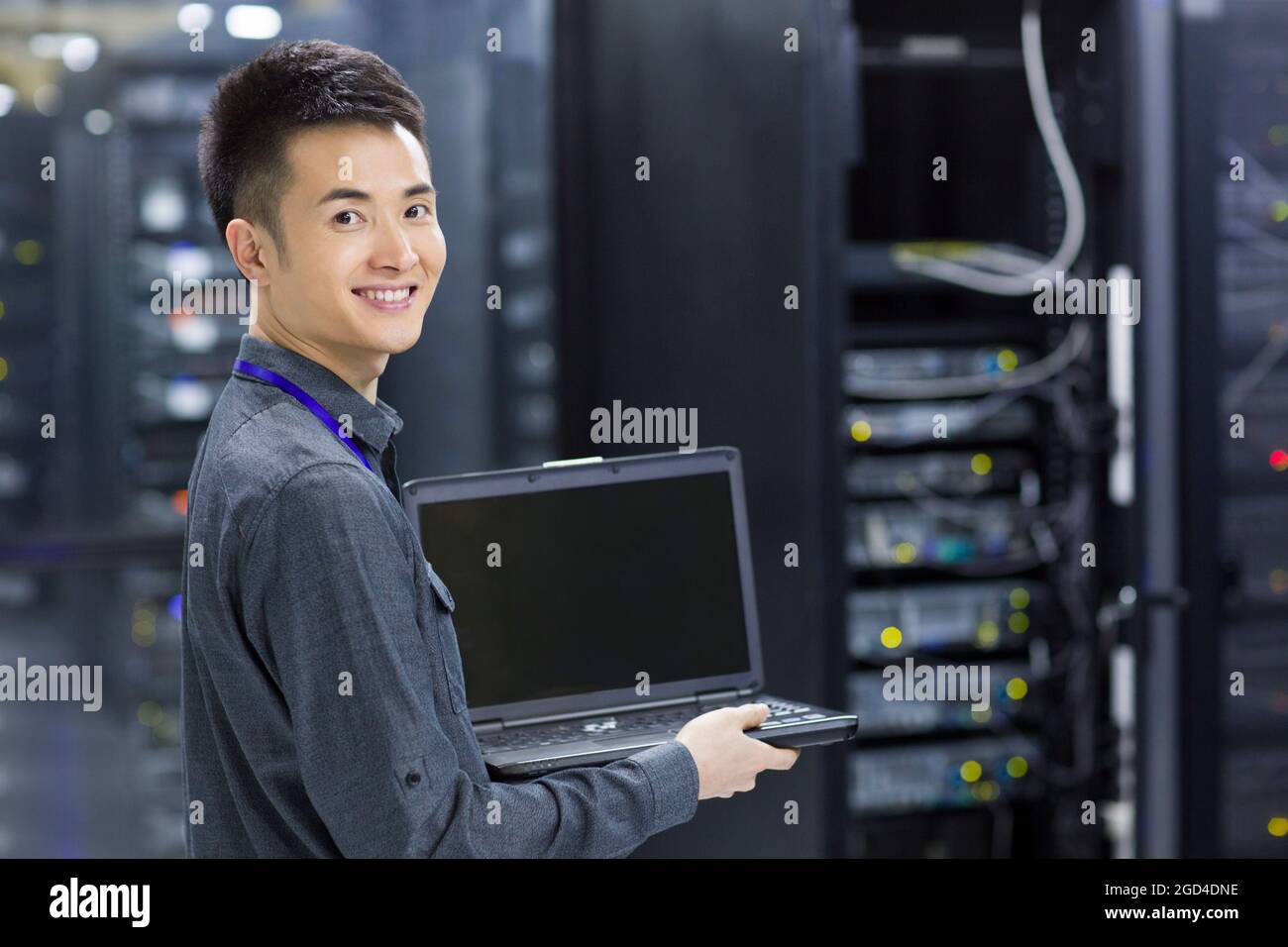 Technician using laptop in computer room Stock Photo - Alamy