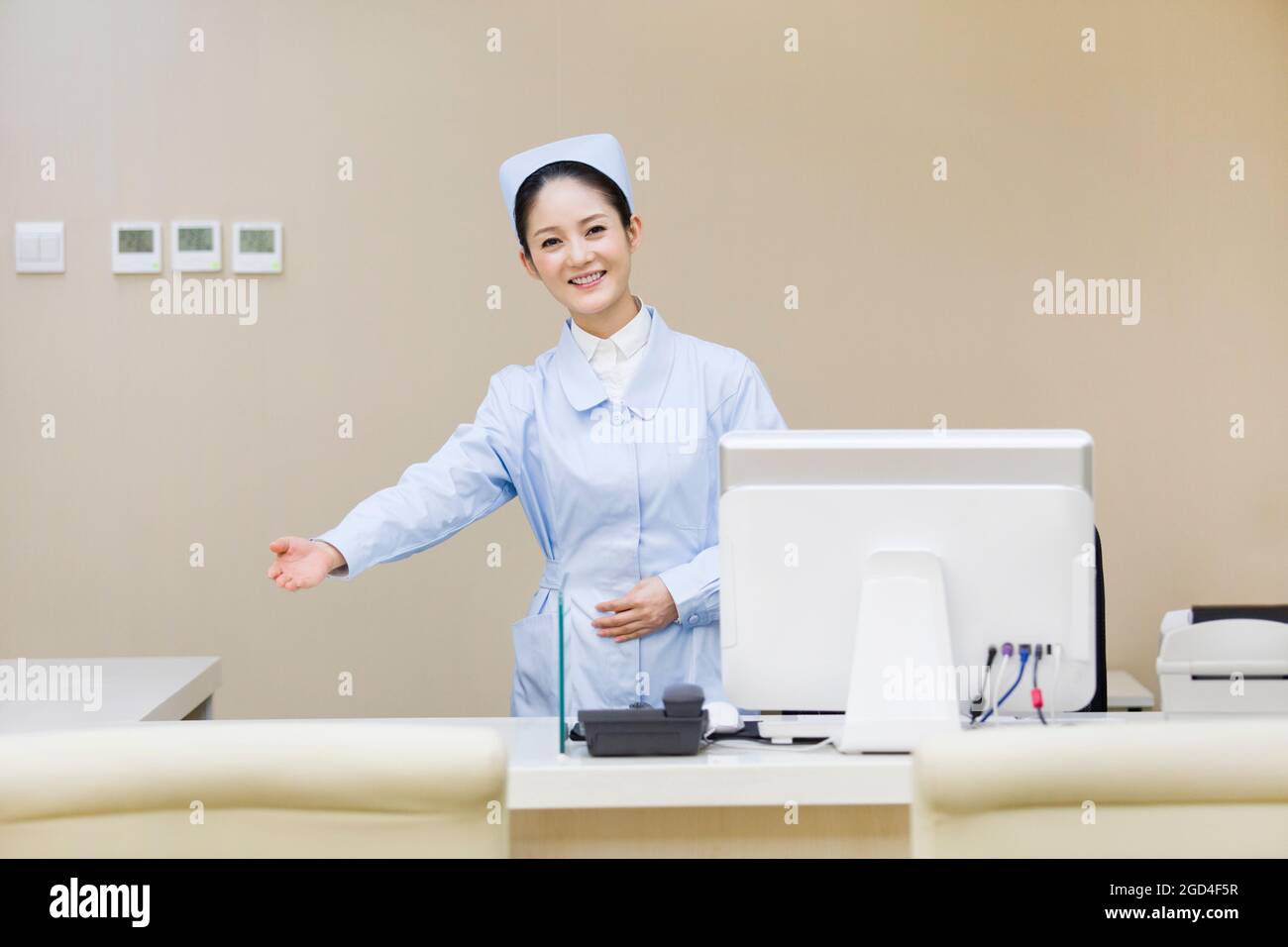 Nurse doing a greeting hand sign Stock Photo - Alamy
