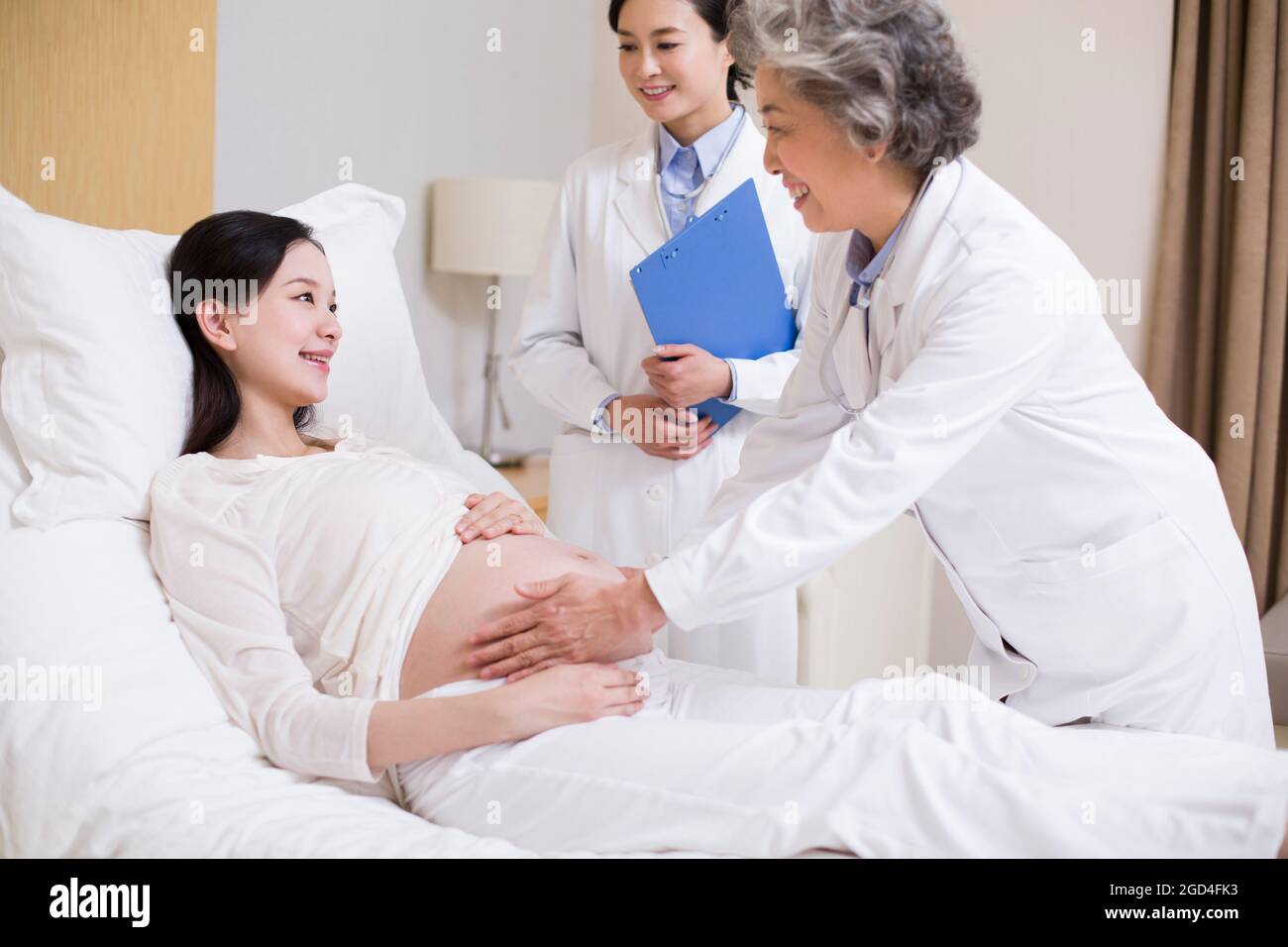 Pregnant woman in hospital ward with doctors Stock Photo - Alamy