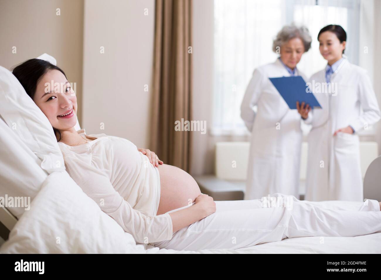 Pregnant woman in hospital ward with doctors Stock Photo - Alamy