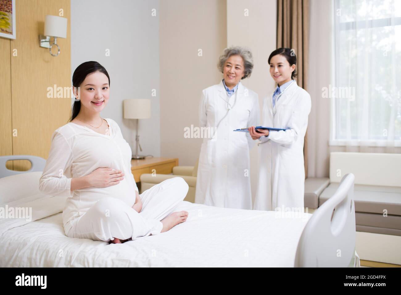 Pregnant woman in hospital ward with doctors Stock Photo - Alamy