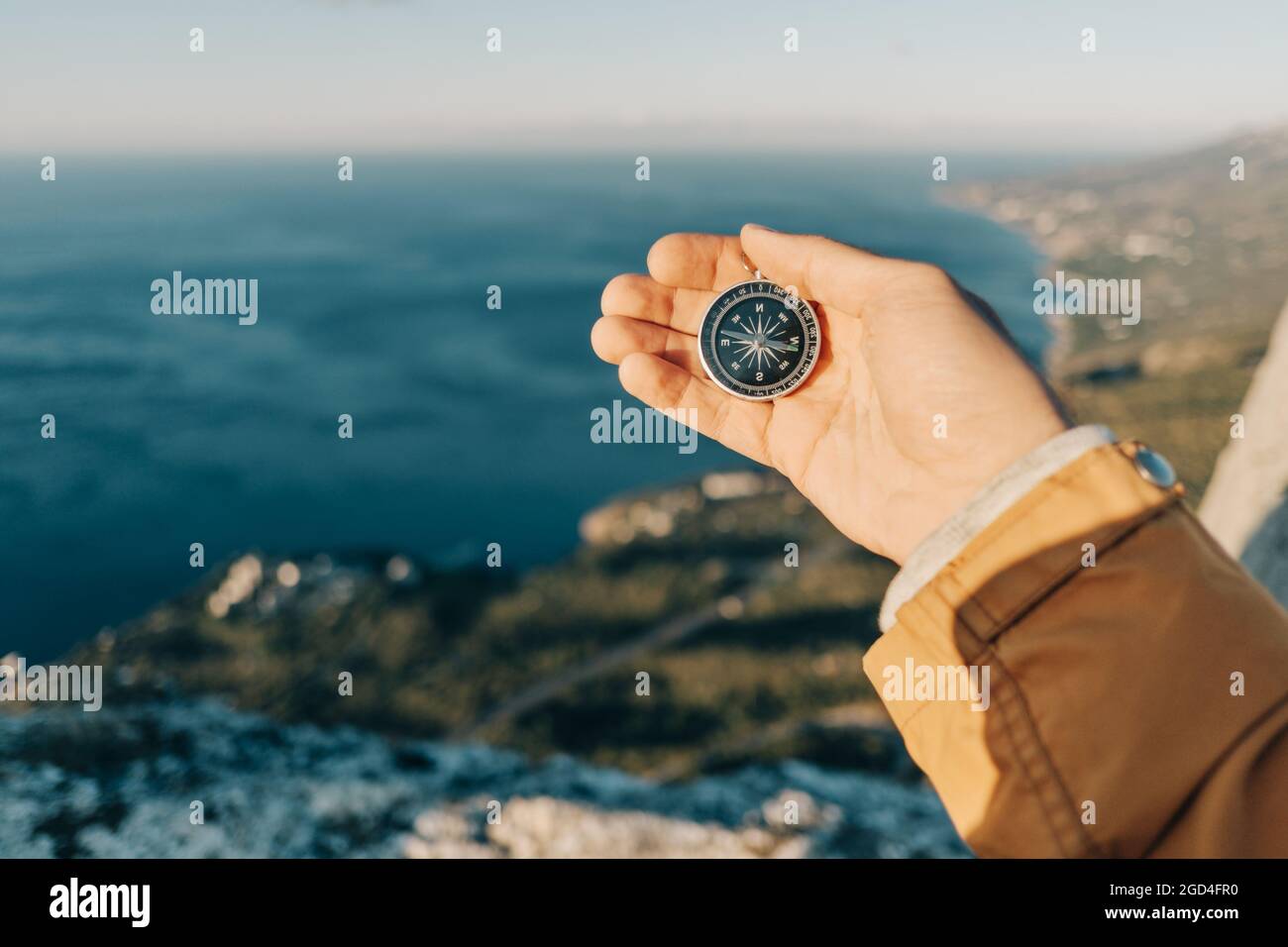 Traveler in the mountains uses a compass Stock Photo - Alamy