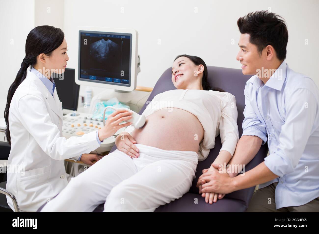 Young couple receiving ultrasound examination in hospital Stock Photo ...