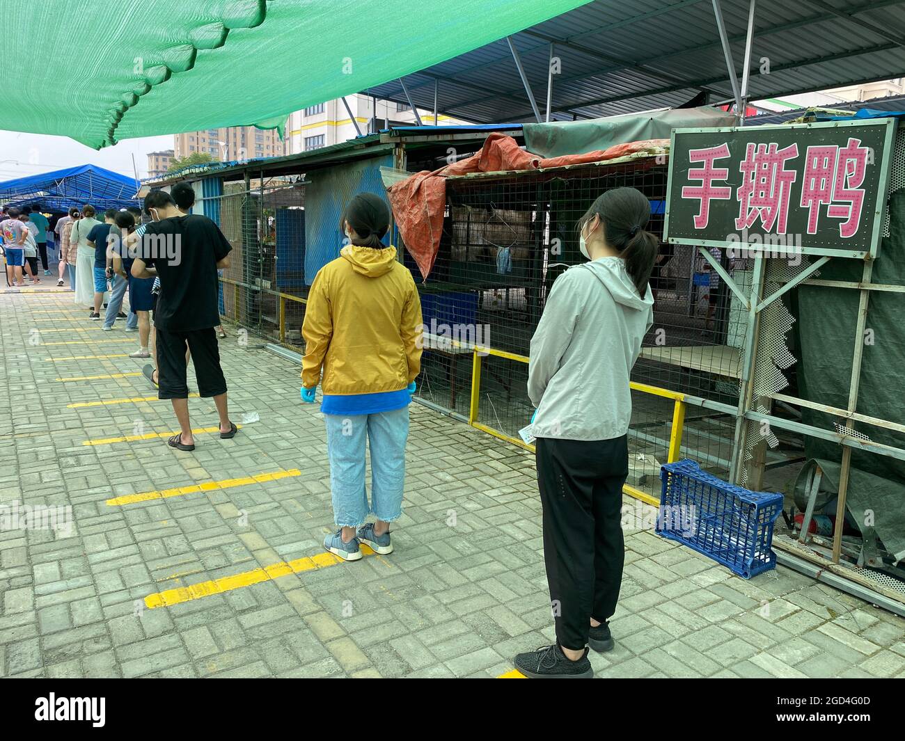 Local citizens line up while keeping social distance at a test center ...