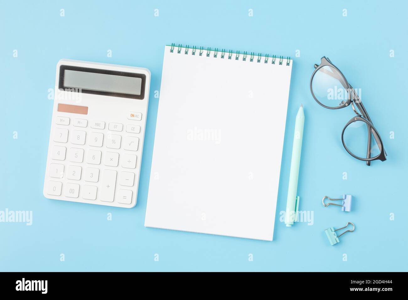 Office desk with calculator, notepad and glasses Stock Photo - Alamy