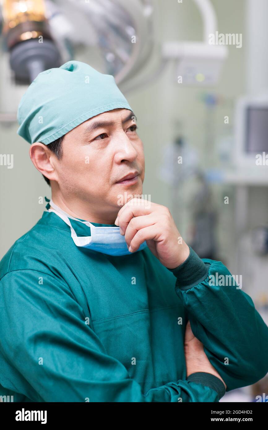 Portrait of surgeon hand on chin Stock Photo - Alamy