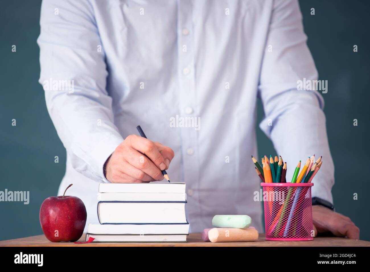 Back to school concept: teacher giving books to her studens in the ...