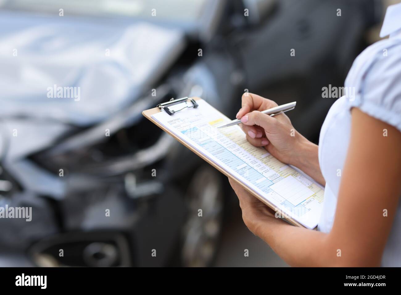 Insurance agent conducts inspection of the damaged car by filling out ...