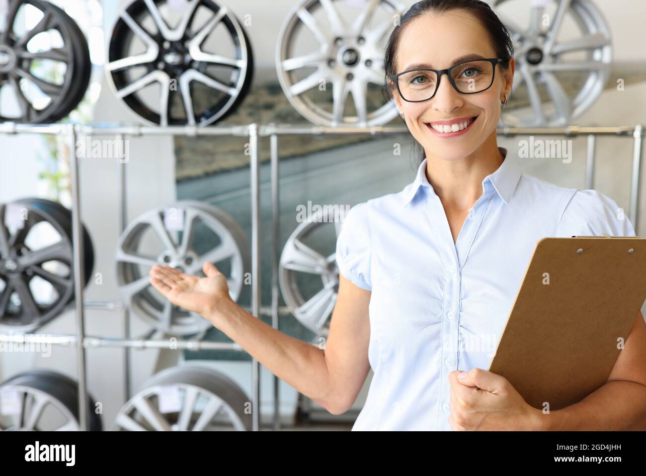 Smiling female consultant recommends car rims closeup Stock Photo - Alamy