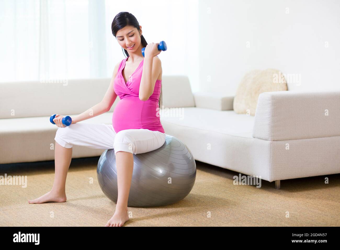 Young pregnant woman taking exercise Stock Photo - Alamy