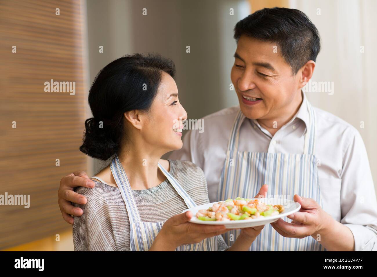 Mature couple enjoying food in kitchen Stock Photo - Alamy