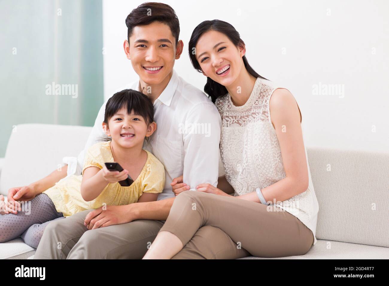 Cheerful family watching TV at home Stock Photo - Alamy