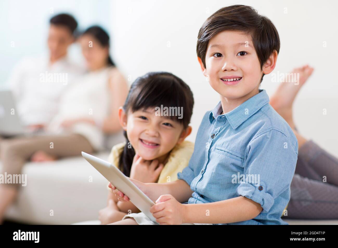 Happy young family using digital gadgets at home Stock Photo - Alamy